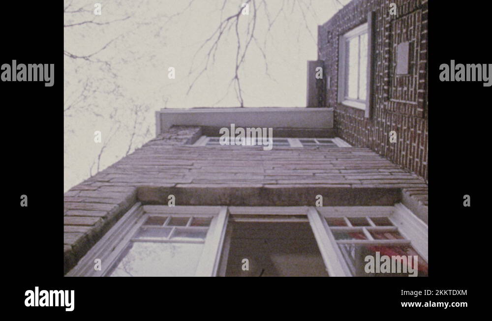 1970s: Boy climbs into window. Low angle, boy jumps from window. High ...