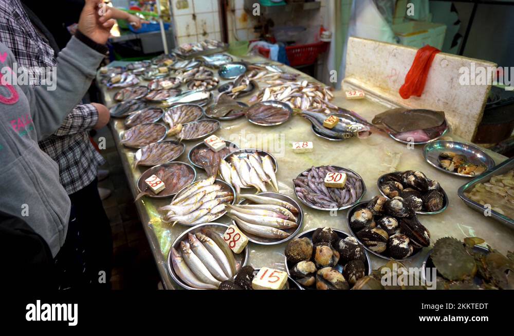 People bartering at fish market in front of table with loads of ...