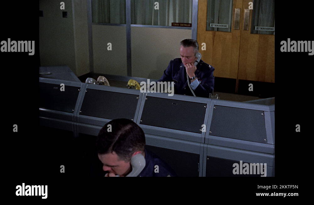 1960s: film slate clapper board. Uniformed Air Force men sit at bank of ...