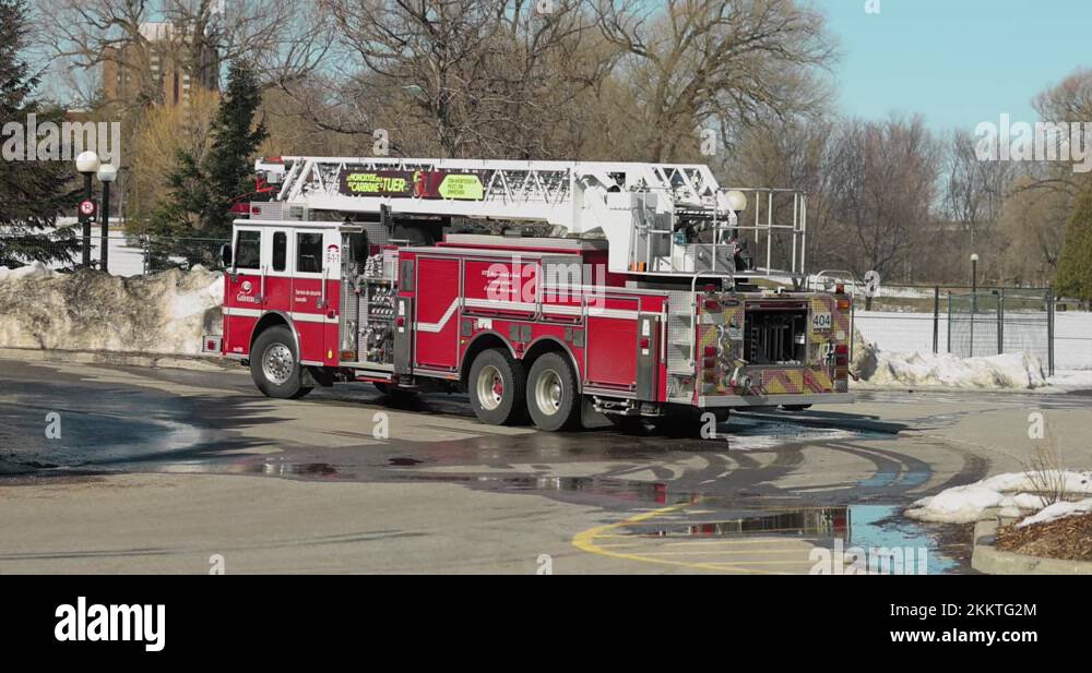 Fire truck parked in a parking lot while a crew searches a building in ...