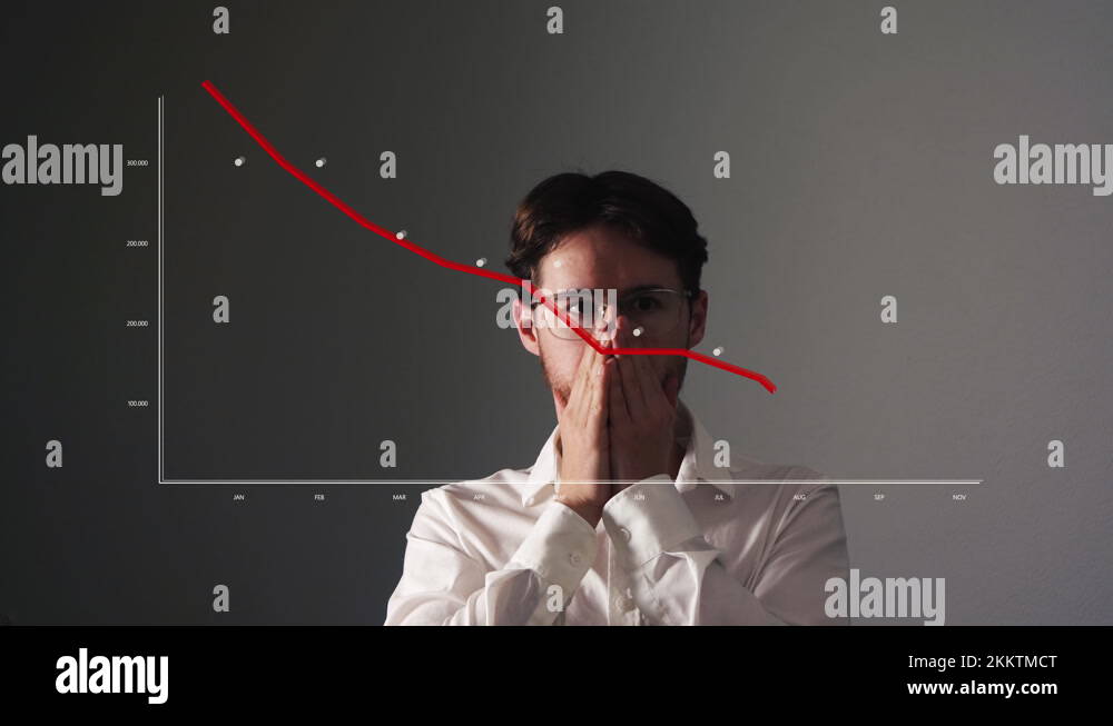 Young businessman looks scared at graph with red falling curve ...