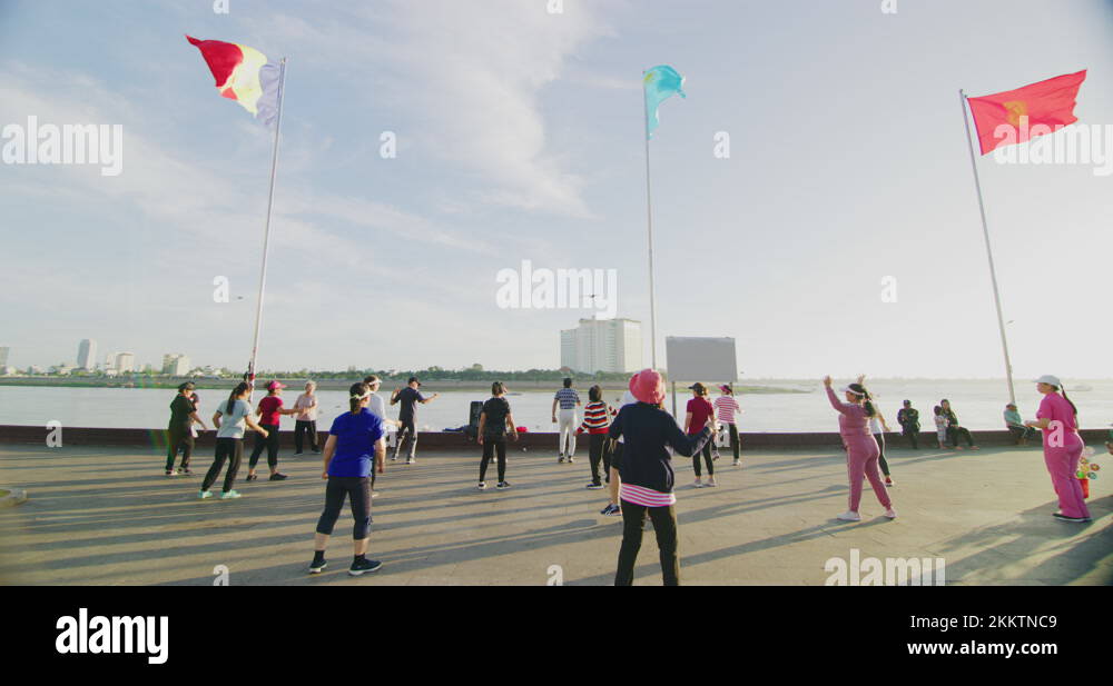 Women Line Dancing Along The Tonle Sap River In Phnom Penh, Cambodia ...