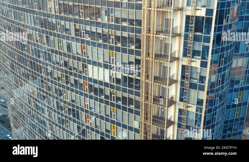 Skyscraper office glassed exterior with sunset sky reflection in the ...