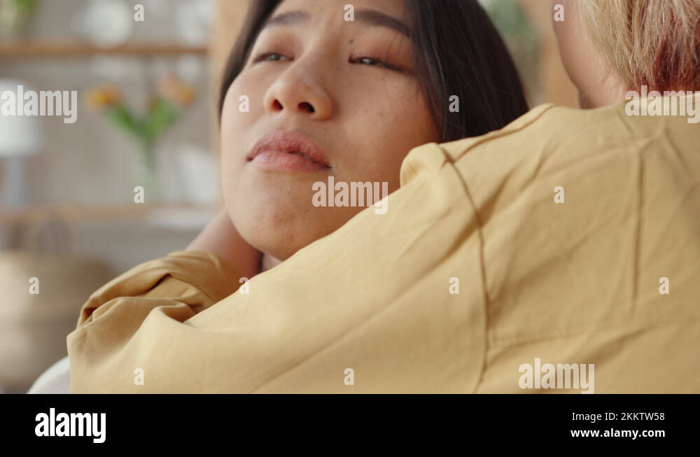 Sad young asian woman hug cuddle embracing with best friend in living ...