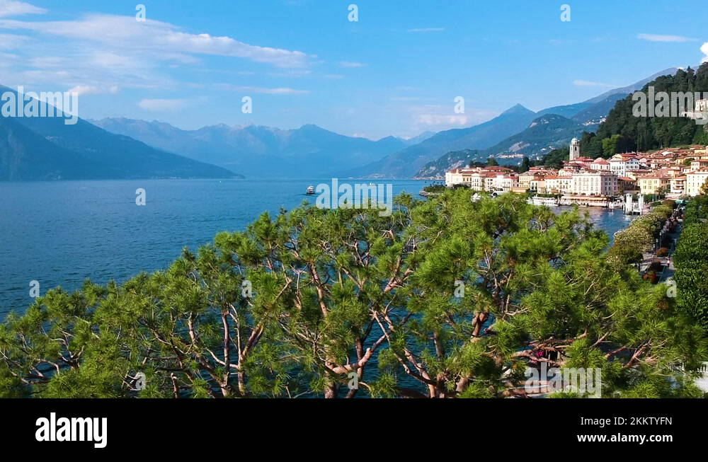 Drone rising above tree top to reveal beautiful Lake Como and ...