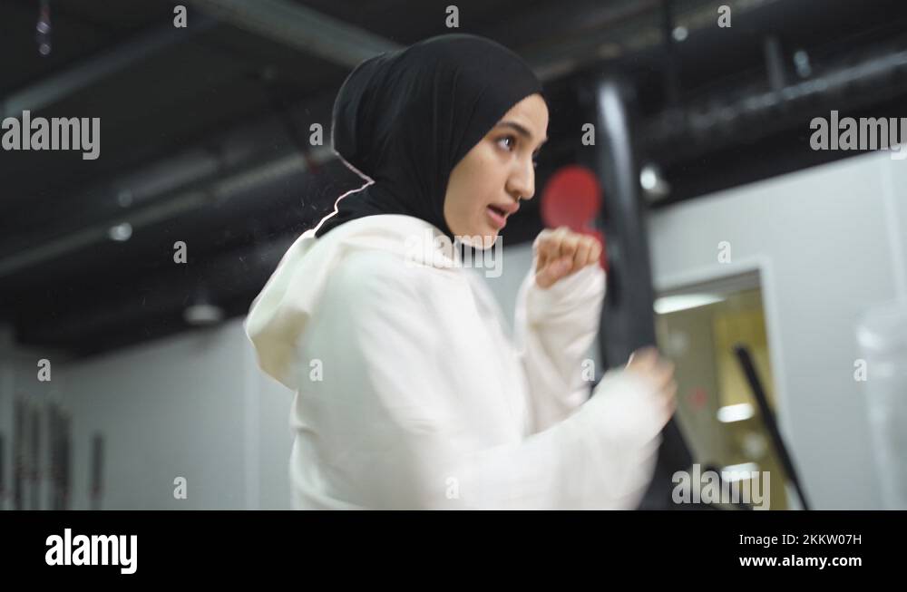 Muslim female boxer in a sports hijab is engaged in boxing, an Arab ...