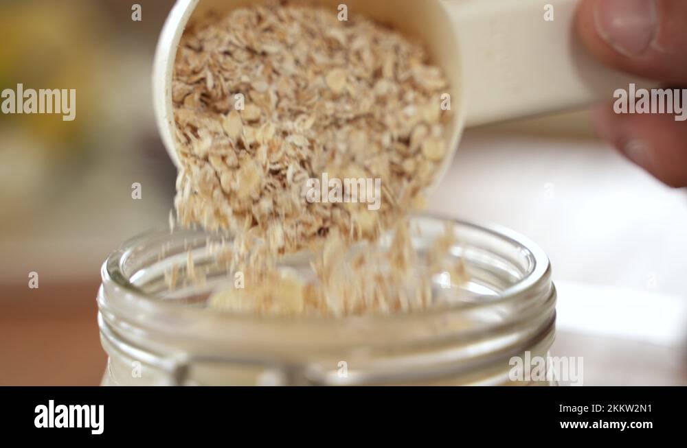 Hand Pouring Oat Flakes in Glass Jar, Slow Motion, Extreme Close Up ...