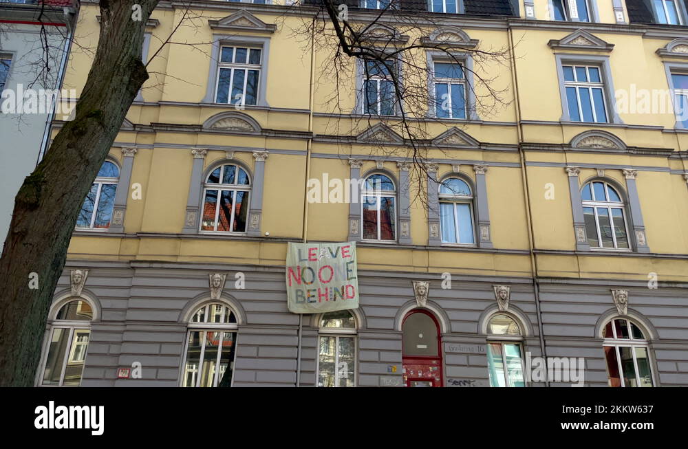 Slow tilt down of apartment building with leave no one behind message ...