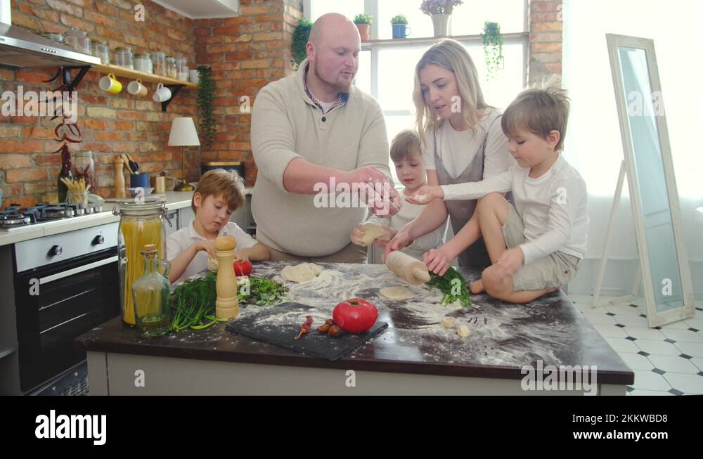 Big and lovely family of five bake pizza with mess in the kitchen ...