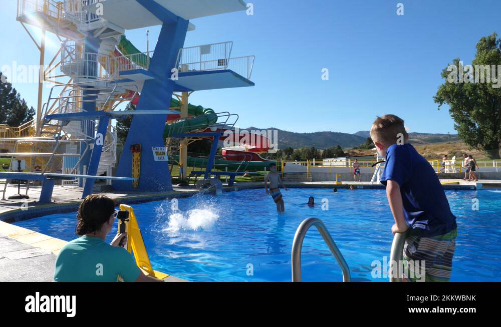 Family at the pool kids jumping off diving boards together Stock Video ...