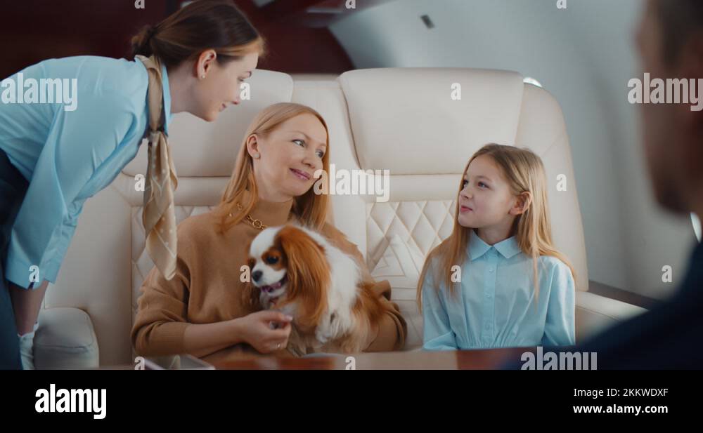 Flight attendant taking order from family in first class airplane ...