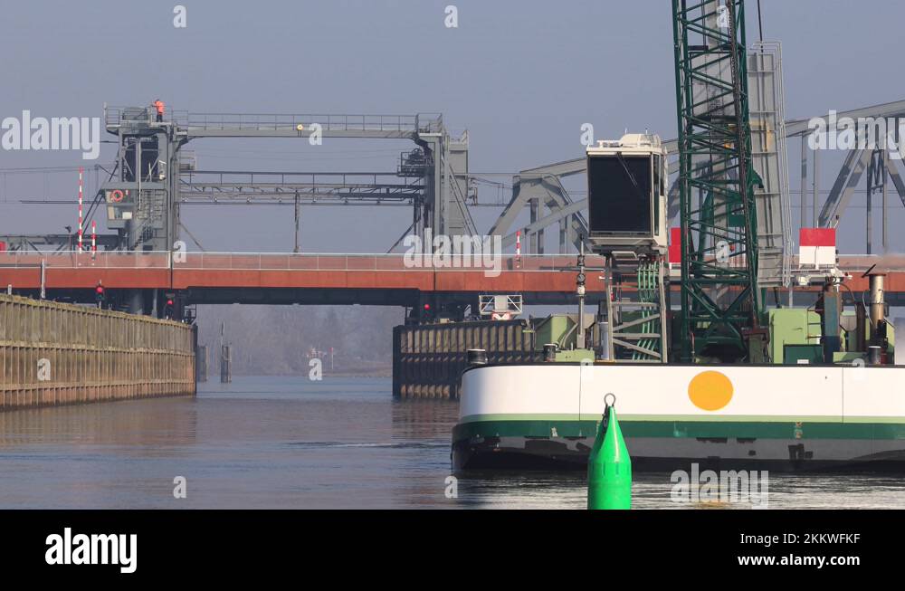 Dredging ship in front of a draw bridge clearing the waterway of river ...