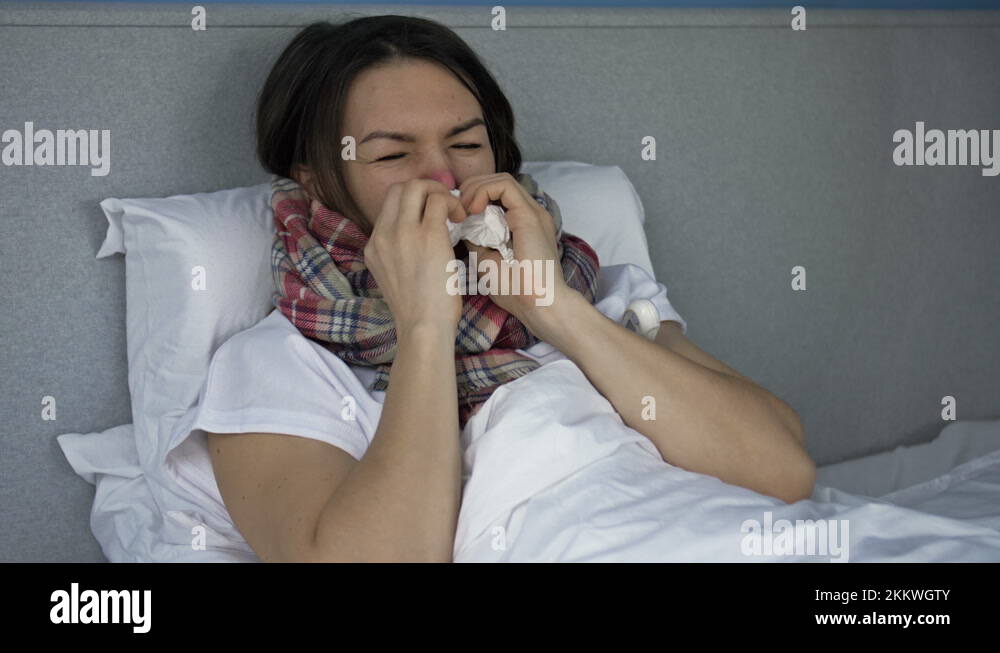 Young woman fell ill. She has a cough, chills, a runny nose. Flu, cold ...