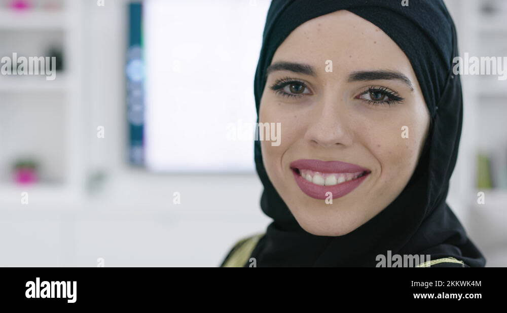 Muslim woman wearing islamic hijab clothes sitting on sofa watching TV ...