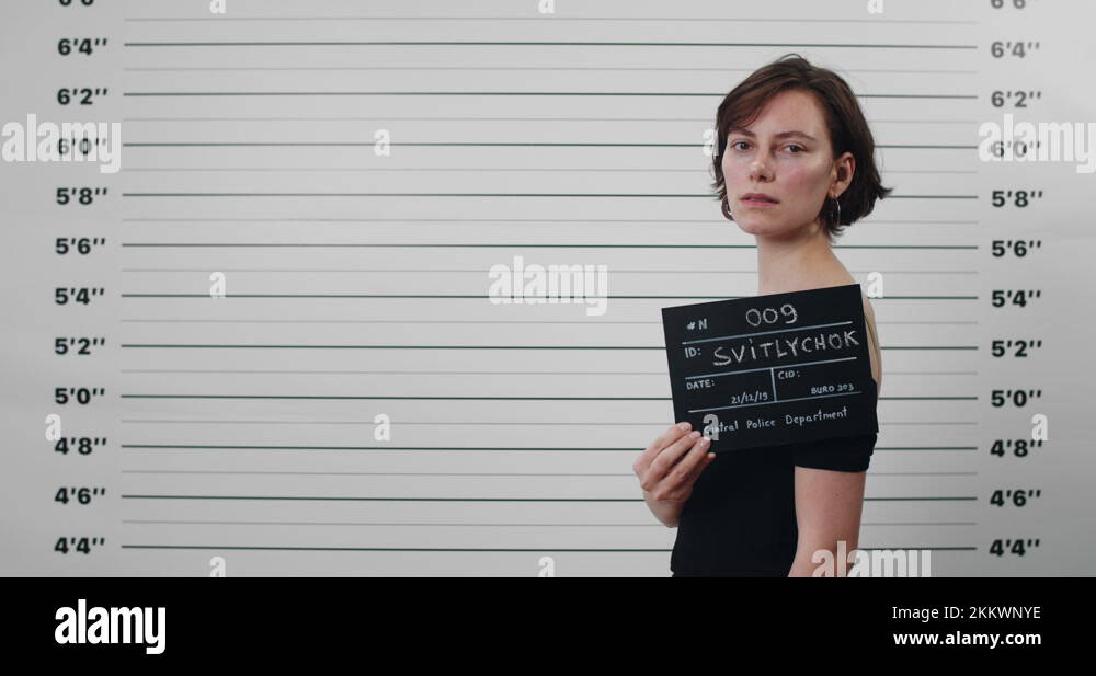 Mugshot of criminal young woman with short haircut turning head and ...