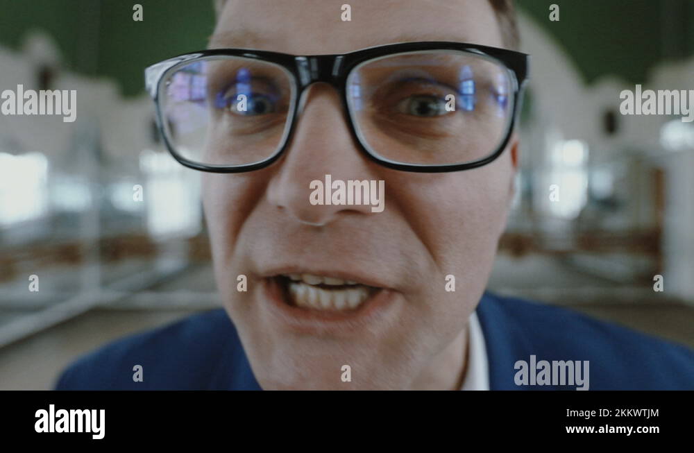 A young guy with glasses funny and emotional looks and speaks into the ...