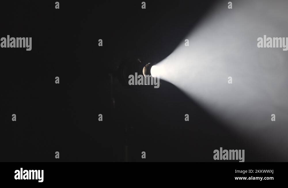 Floodlight beam turns slowly and flares the screen. Stage spotlights ...