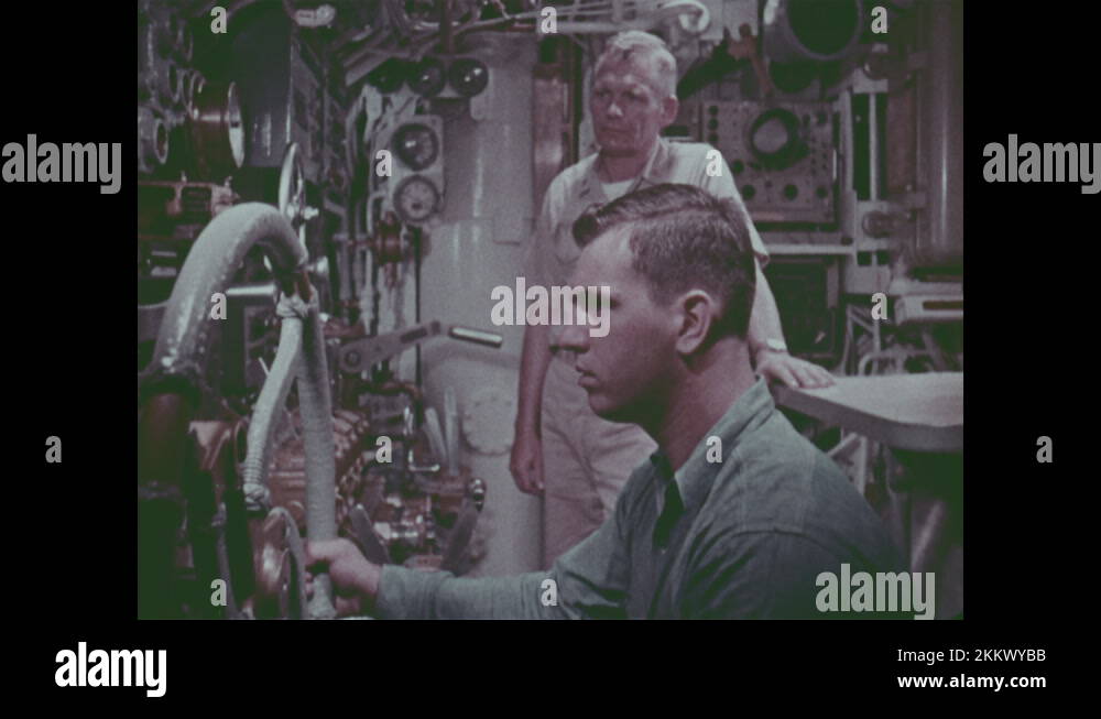 1960s: Men at controls of submarine. Men look into periscope. Ocean ...