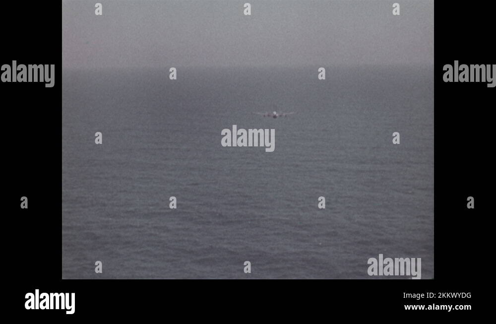 1960s: Airplane flies over ocean. Man in cockpit watches radar. Plane ...