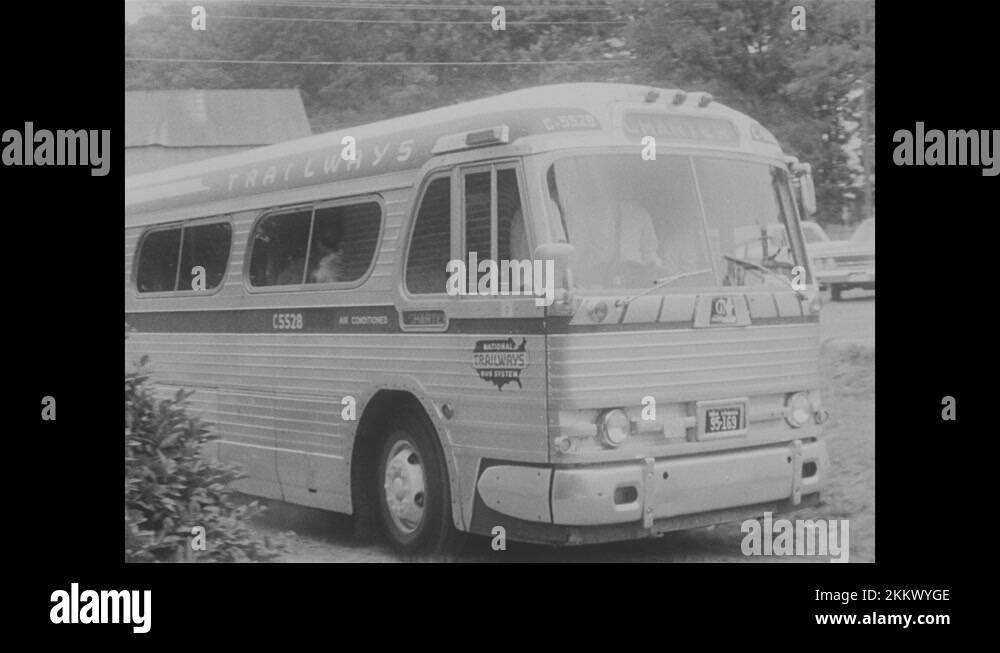 1960s: Hand closes latch on side of bus. Young man by bus. Bus pulling ...