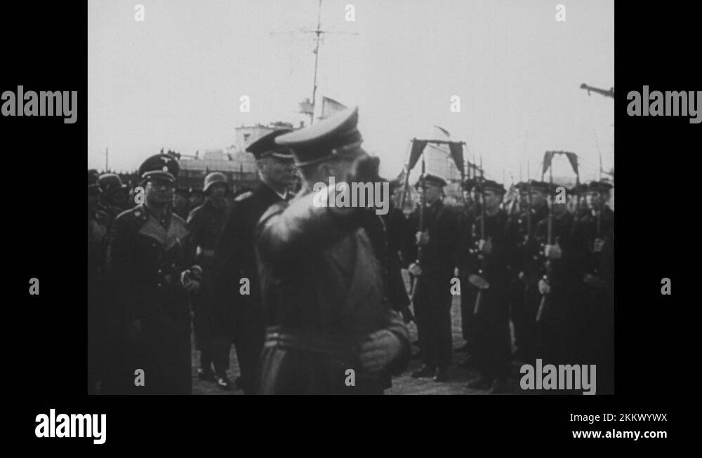 1930s Germany: Hitler gestures. Nazi parade. Nazi flag flies. People ...
