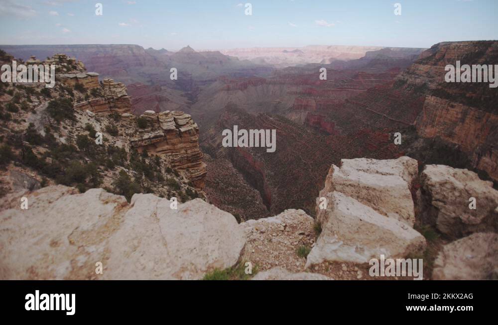 Grand Canyon cliff edge gimbal push forwards reveals valley below, with ...