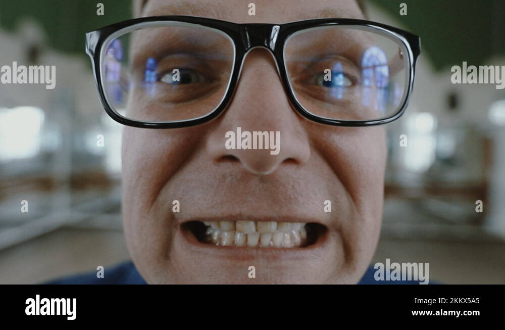 A young guy with glasses funny and emotional looks and speaks into the ...