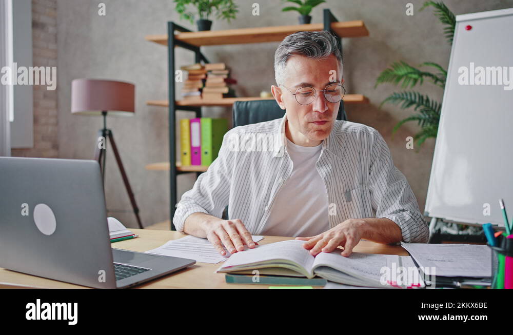 Middle aged professor preparing for online lesson with students ...