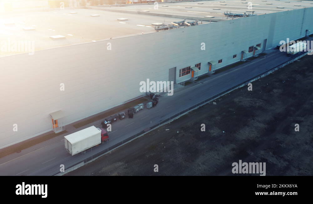 Semi-trailer truck drives along a large warehouse in a logistics park ...