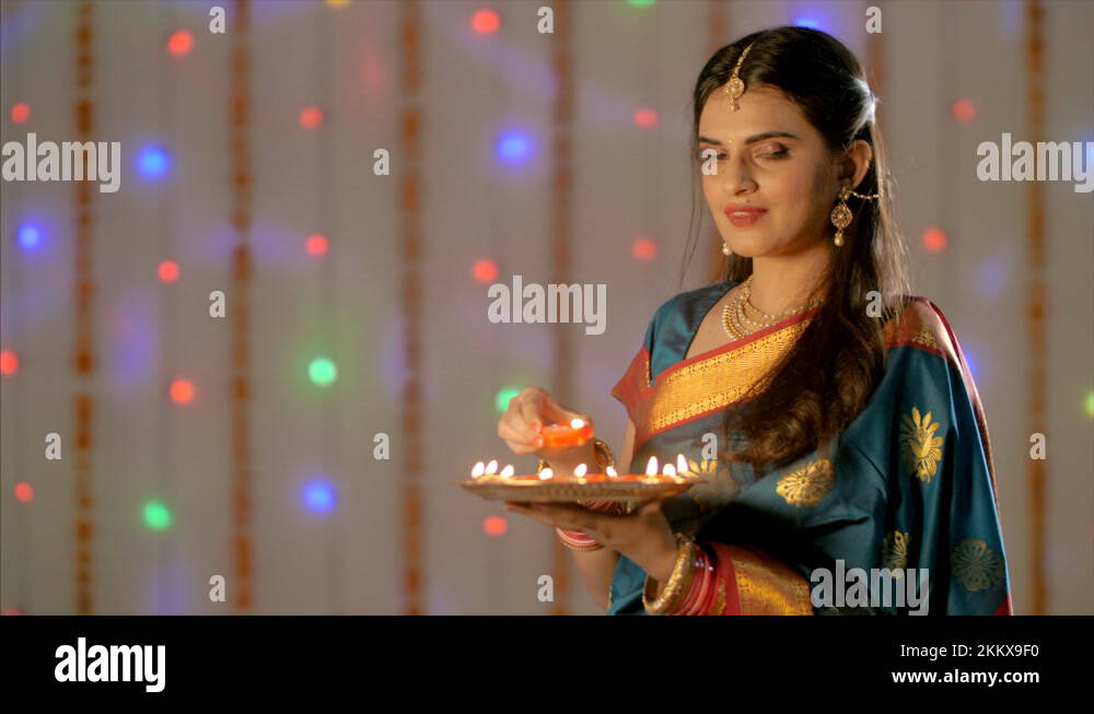 Good looking Indian female in saree holding an oil lamp celebrating her ...