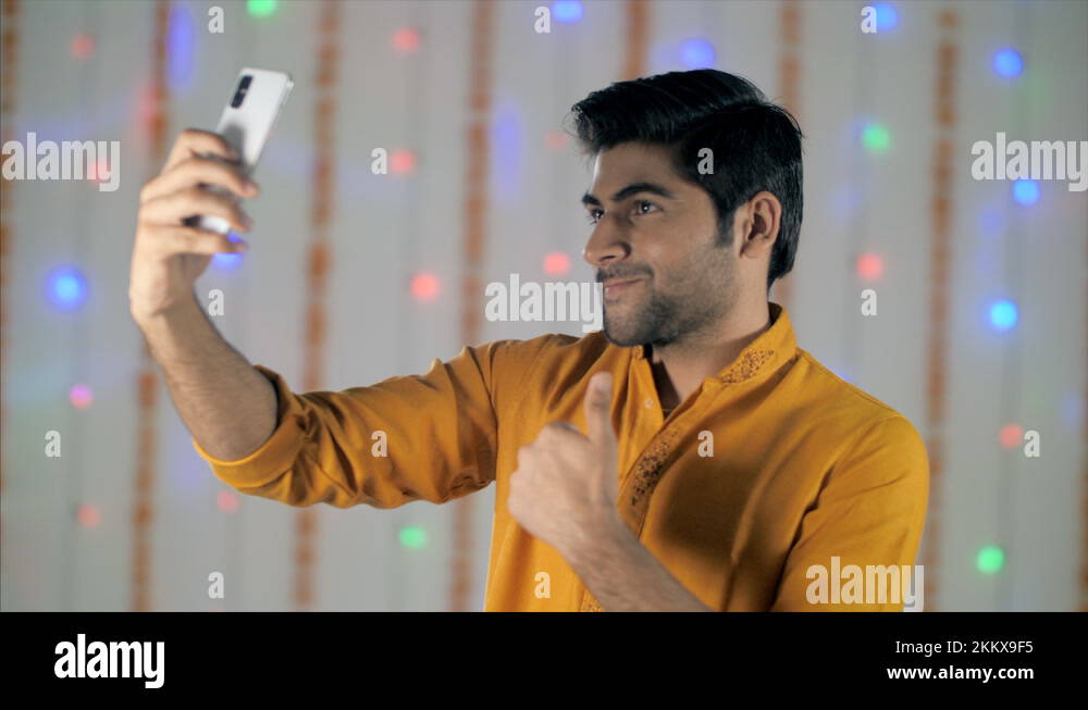 A handsome Indian man in a kurta takes selfies from different angles ...
