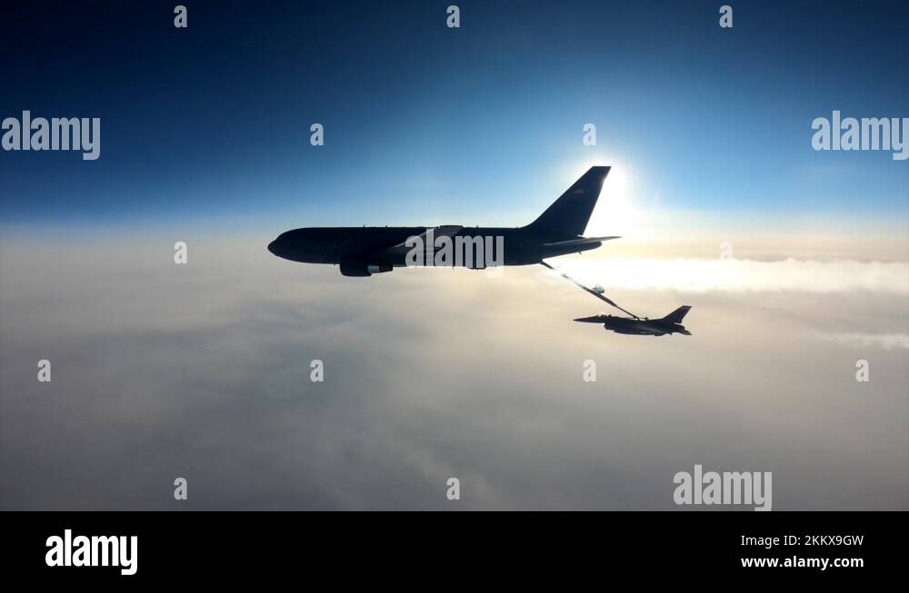 Side view of KC-135 aerial refueling F-16 Fighting Falcon above clouds ...