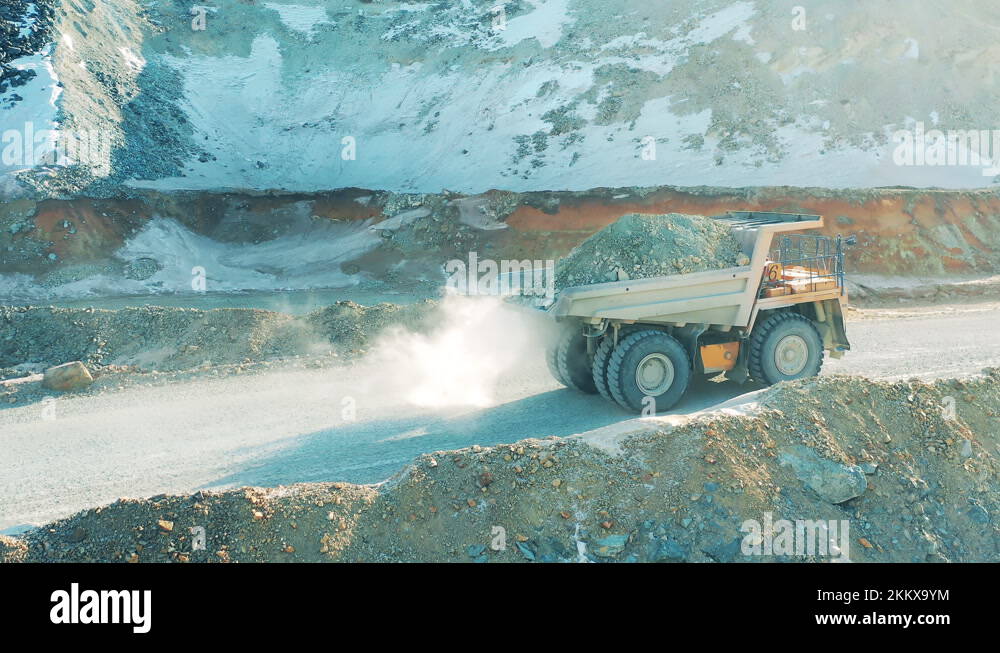 Mining industry concept. Side view of a loaded truck riding along the ...