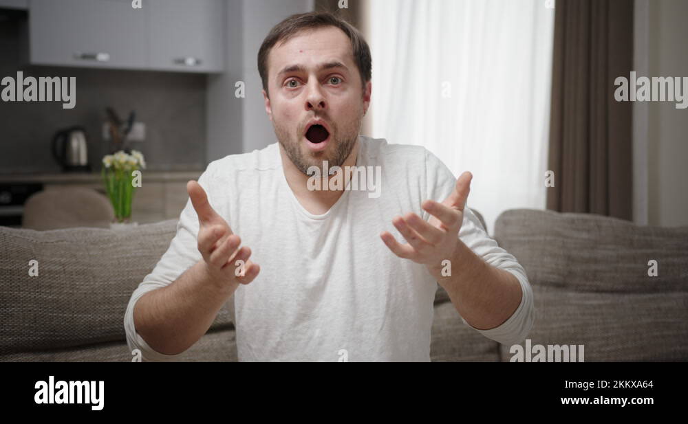 Surprised shocked man puts his hands on his head opens his mouth ...