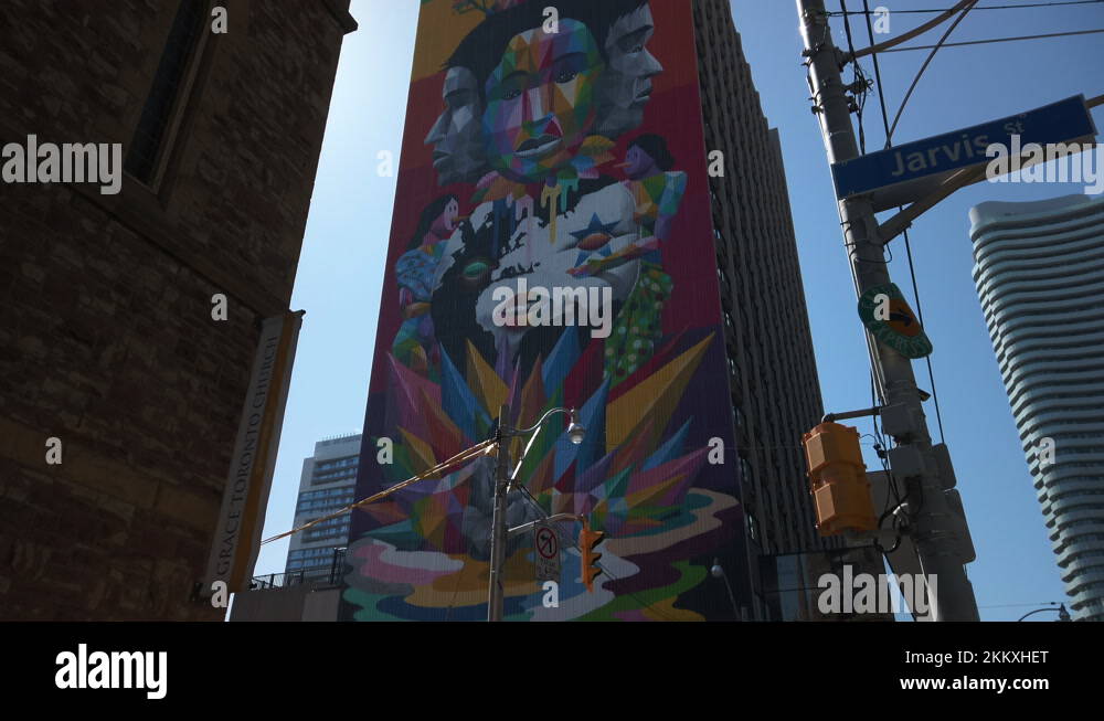 Wide shot with tilt down from tall art mural to street level at ...