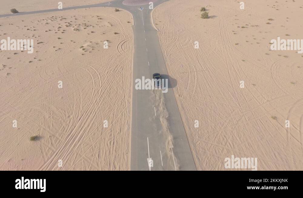FPV aerial view of speeding black Lamborghini Urus on desert road near ...