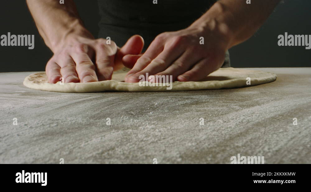 Italian pizza chef carefully shaping dough with his fingers. Process of ...