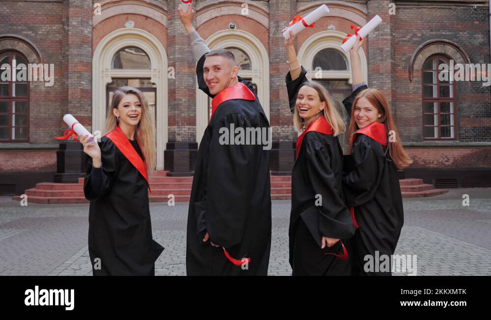 Friends graduate students in gowns with certificates go to academy back ...