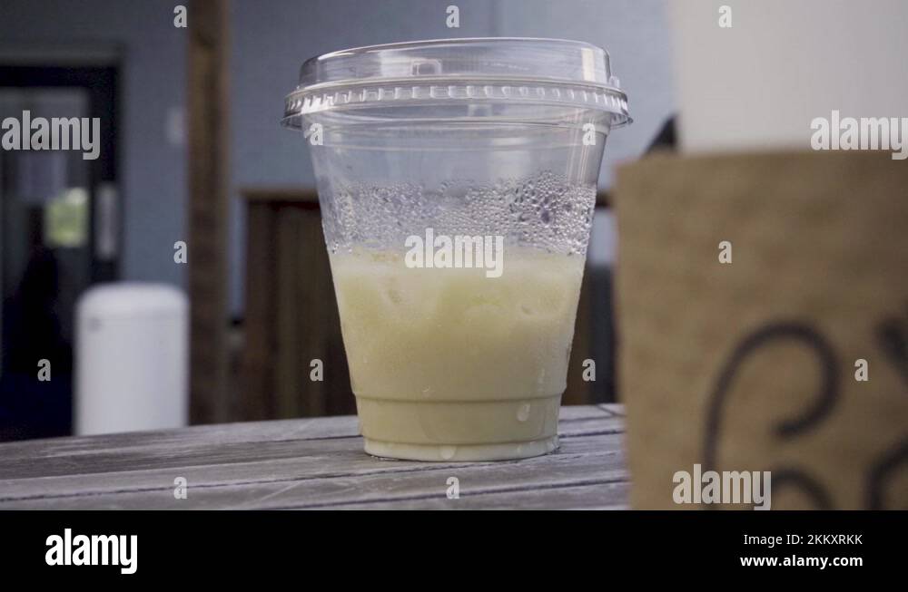 Plastic cup with cold coffee in it, condensation on the cup. A paper ...