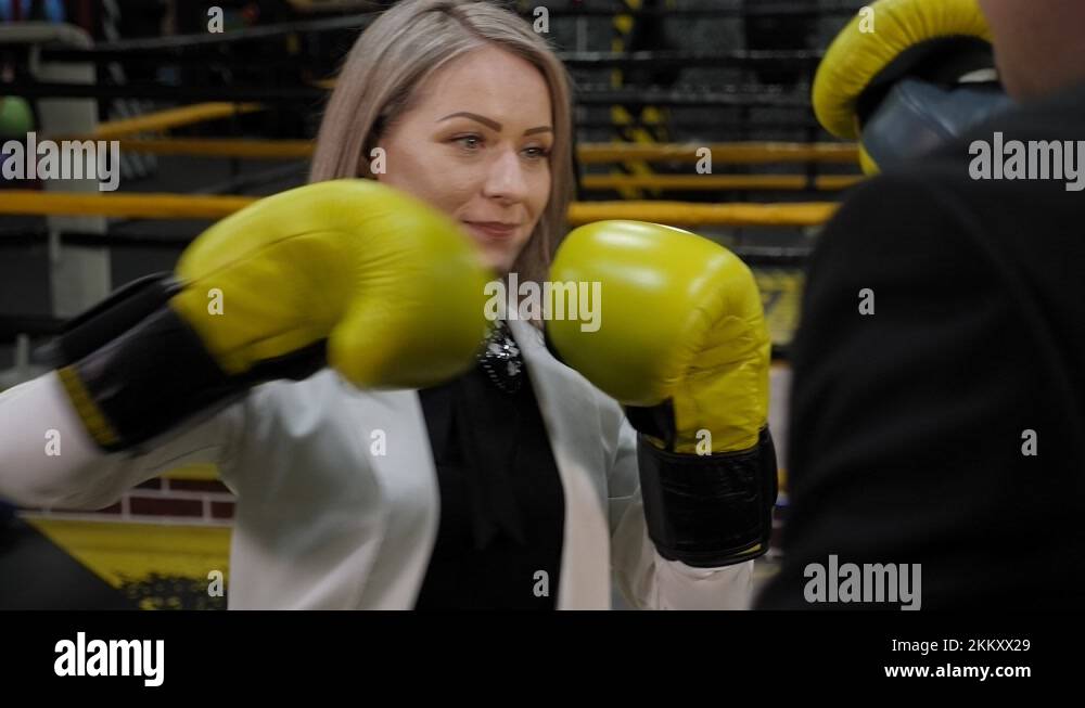 Two businessmen in suits and boxing gloves practice punches in the ...