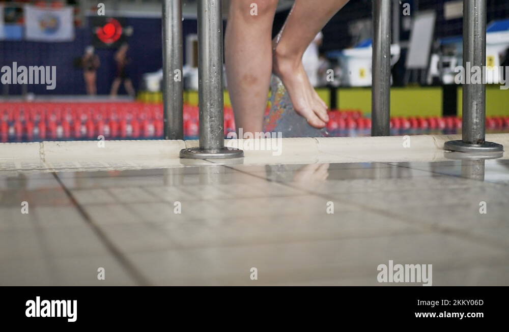legs of a teenage swimmer comes out of the pool after a swim. Drops and ...