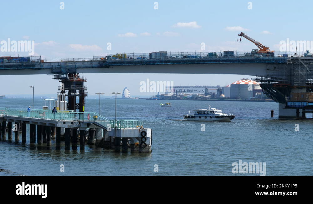 Boat turning in water under bridge construction over the Tama River ...