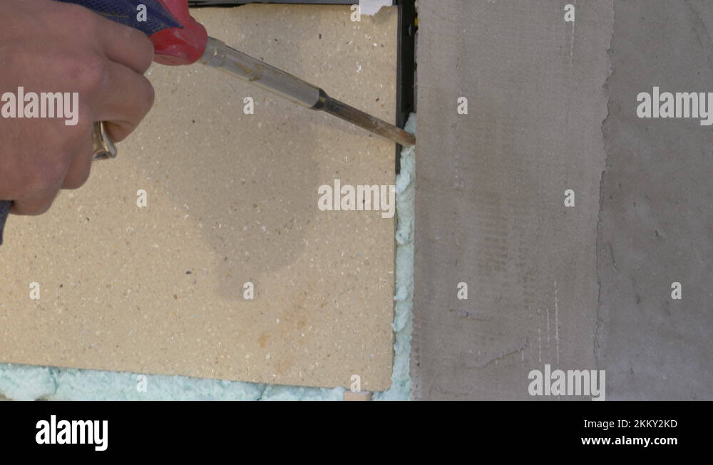 CLOSE UP: Builder mounting windows sprays polyurethane foam into a ...