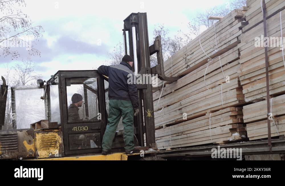 Forklift load stack of timber planks on heavy truck at sawmill factory ...