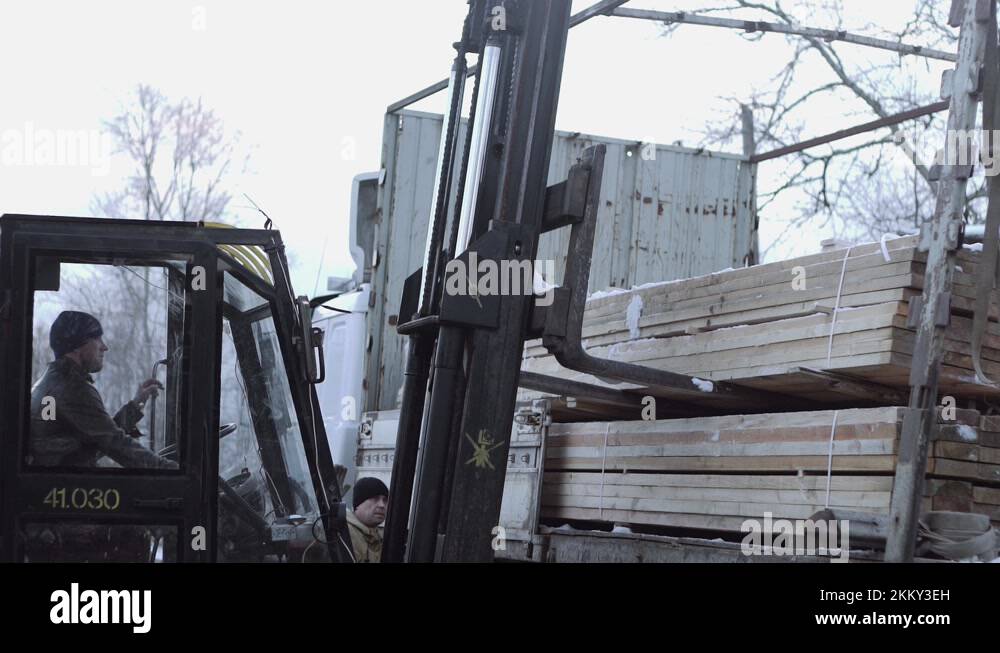Forklift load packs of wood planks on lorry cart at sawmill factory ...