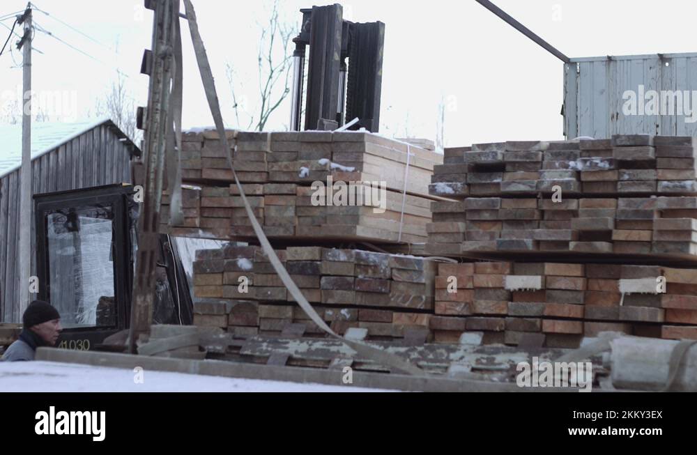 Forklift load packs of wood planks on lorry truck at sawmill factory ...