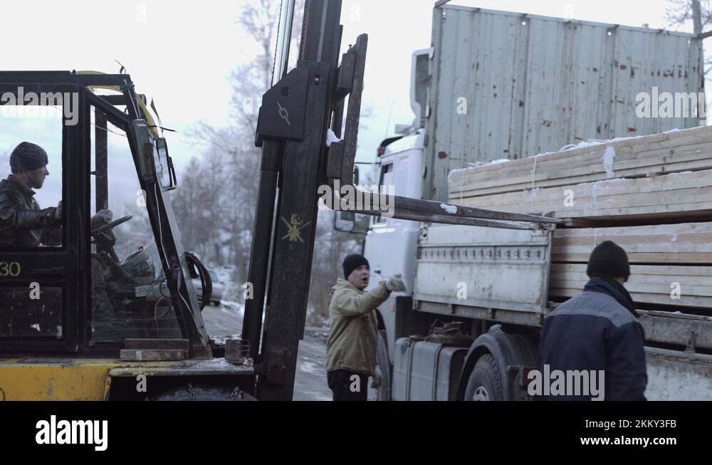 Forklift load packs of wood boards on lorry cart at sawmill factory ...