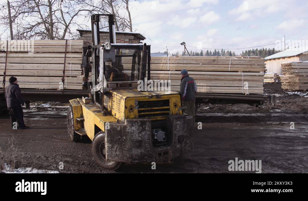 Forklift load stack of wood boards on lorry vehicle at sawmill factory ...