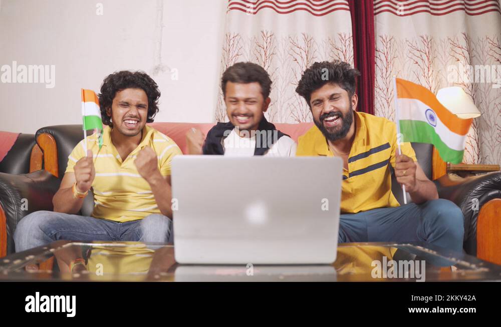 Friends are laughing for winning game while watching cricket in laptop ...