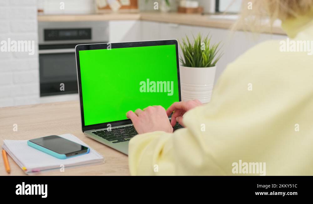 Girl uses green screen chroma key laptop for learning, writes down ...